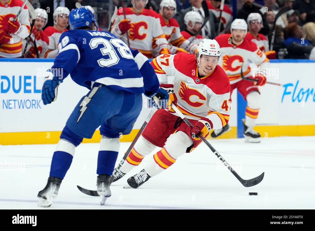 Calgary Flames center Connor Zary (47) works around Tampa Bay Lightning ...