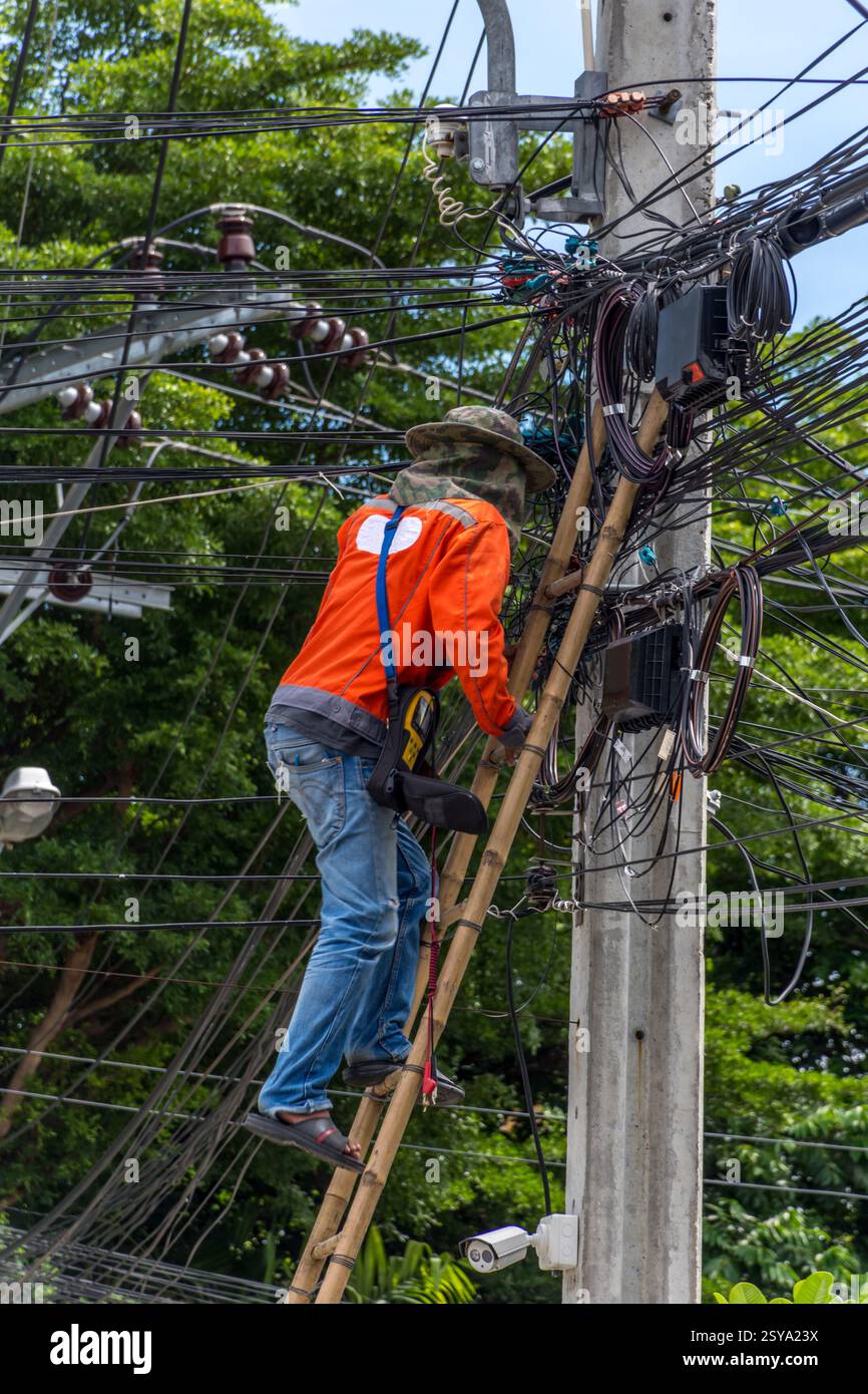 Worker working to install electric line by scaffolding on pickup truck ...