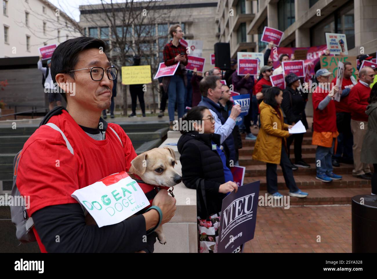 Washington Dc, Virginia, USA. 27th Feb, 2025. A man holds a dog as he ...
