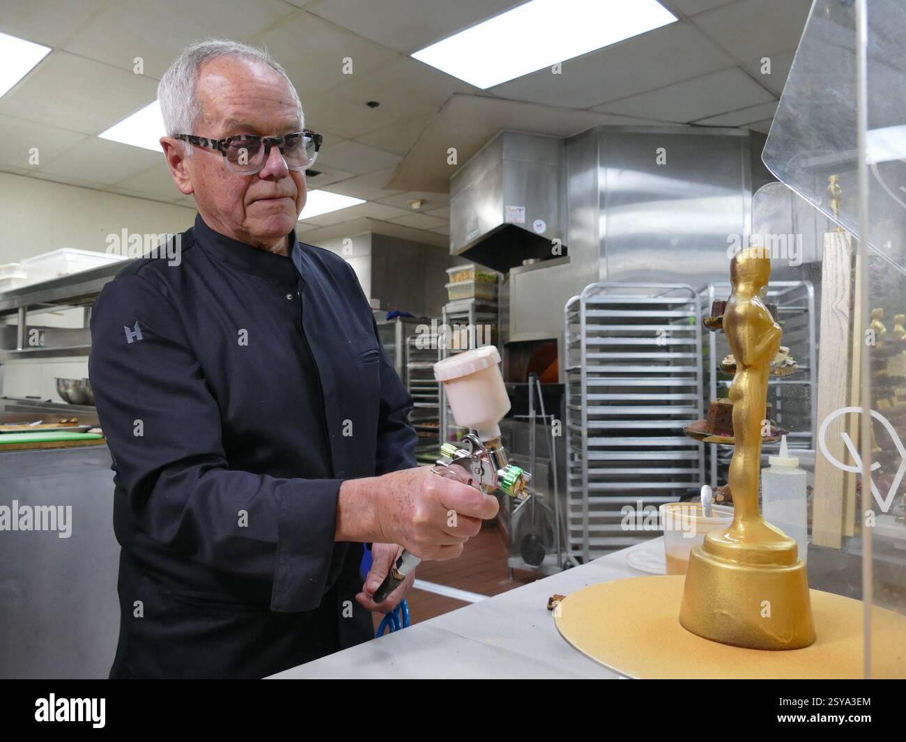 27 February 2025, USA, Los Angeles: Wolfgang Puck sprinkles gold dust ...