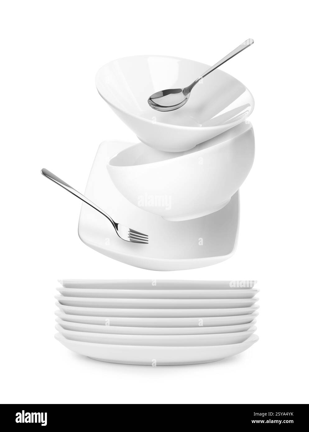 Clean dishware and silverware flying over stacked plates on white ...