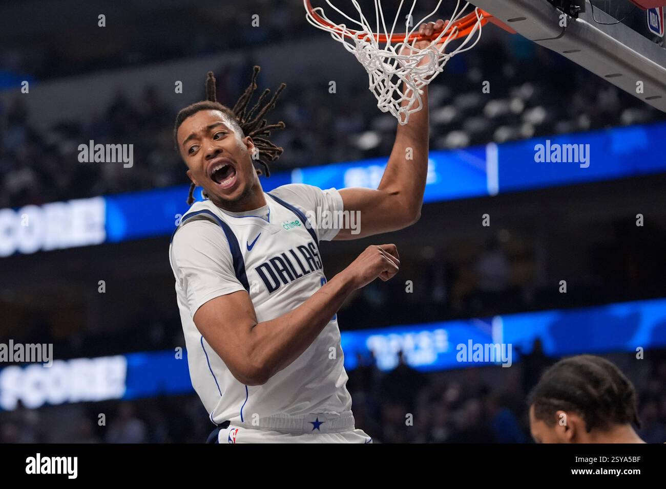 Dallas Mavericks center Moses Brown hangs on the rim after dunking ...