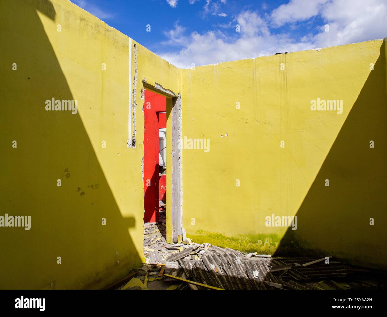 Abandoned building with no roof, yellow walls with some reds at the ...