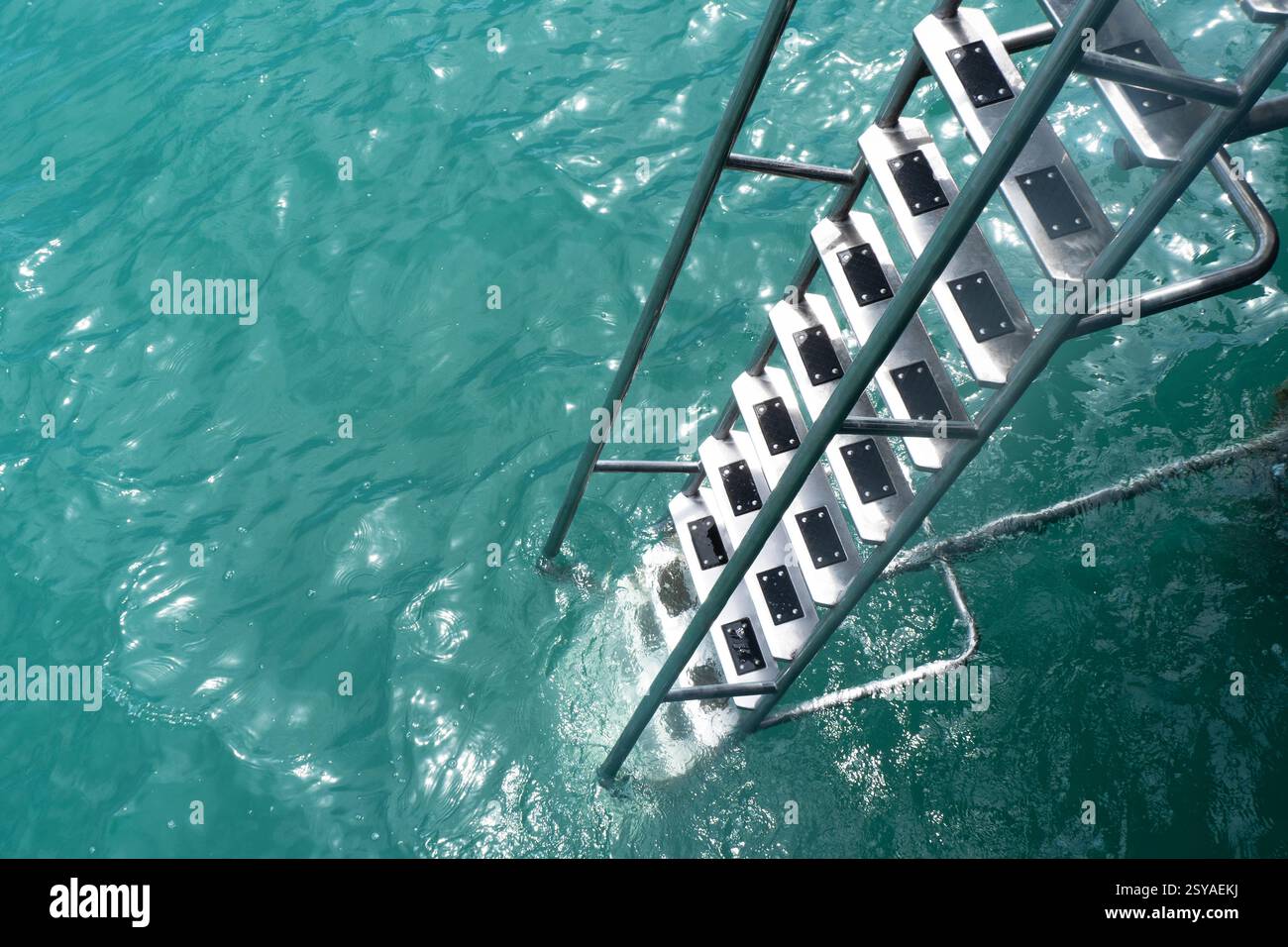 Wooden pier with ladders to the sea. Handrail. Stainless steel ladder ...