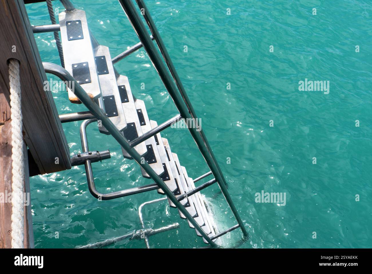 Wooden pier with ladders to the sea. Handrail. Stainless steel ladder ...