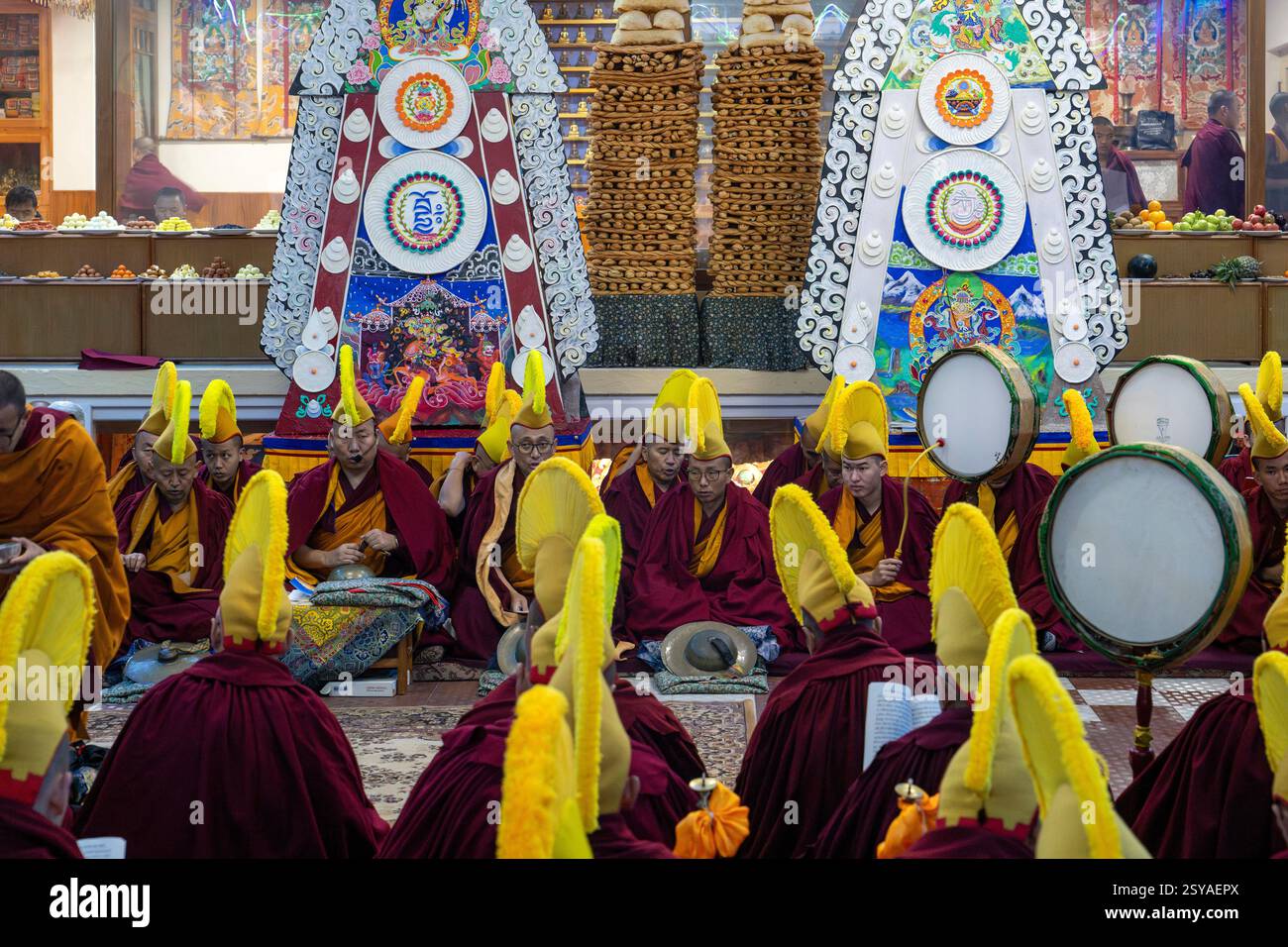 Exiled Tibetan Buddhist monks in yellow ceremonial hats conduct ritual ...