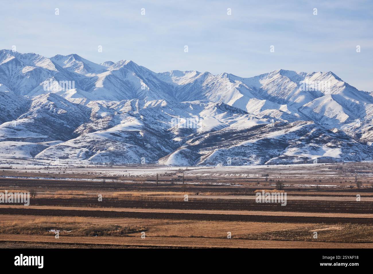 Spring natural landscape Kyrgyzstan. Plowed fields and snow-capped ...