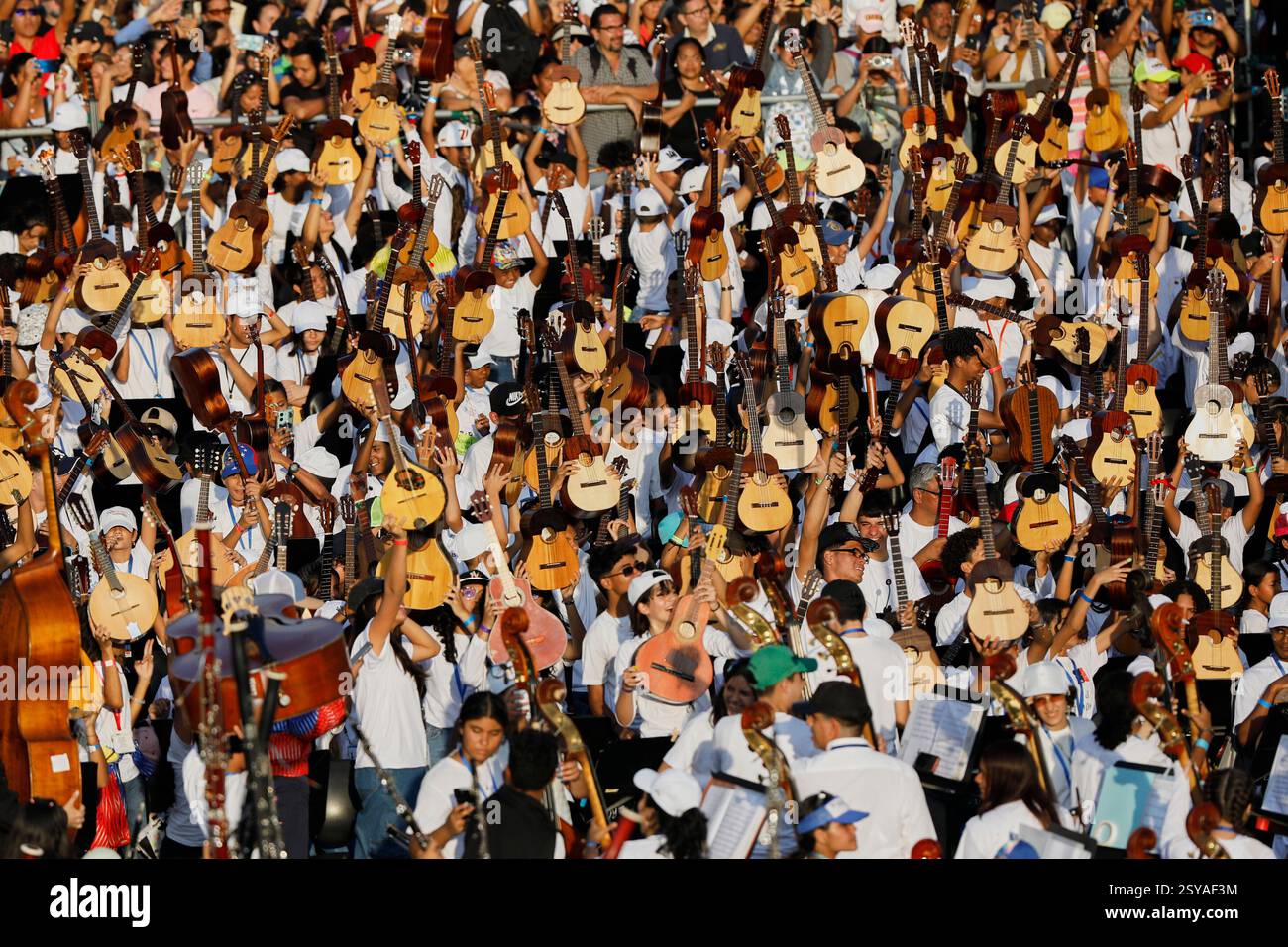 Youth raise their instruments during a concert celebrating the 50th ...