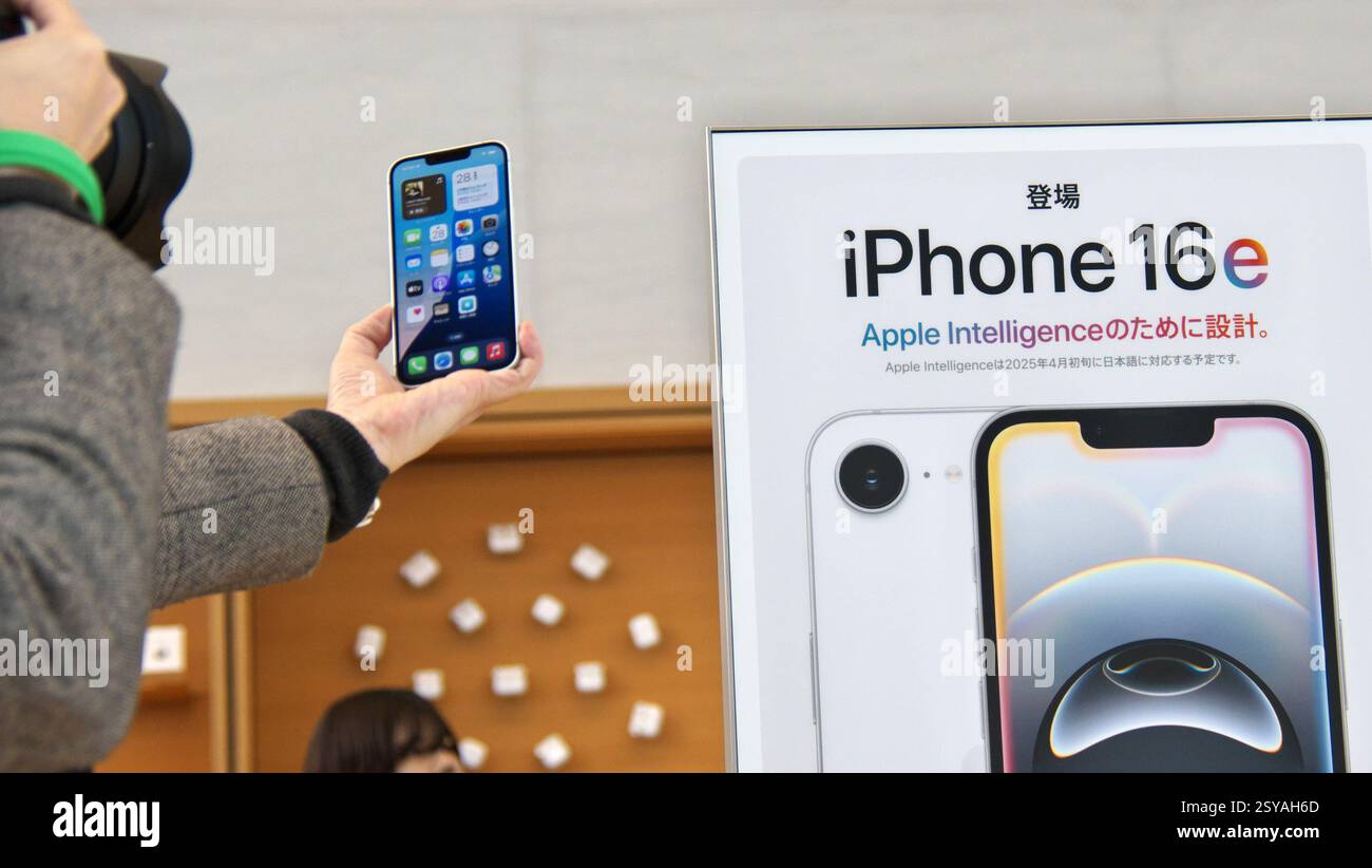 A journalist takes photo Apple's new iPhone 16e during the launch day ...