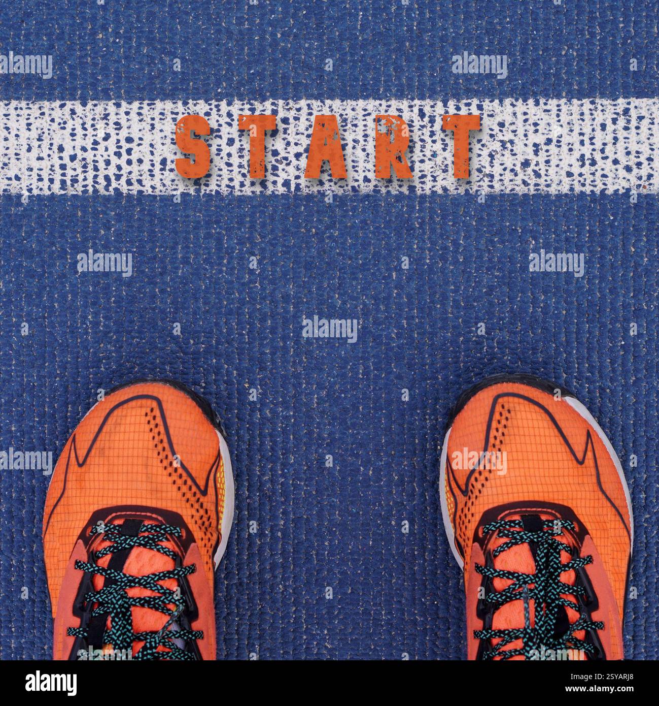 start concept. feet in orange running shoes at the starting line of a ...