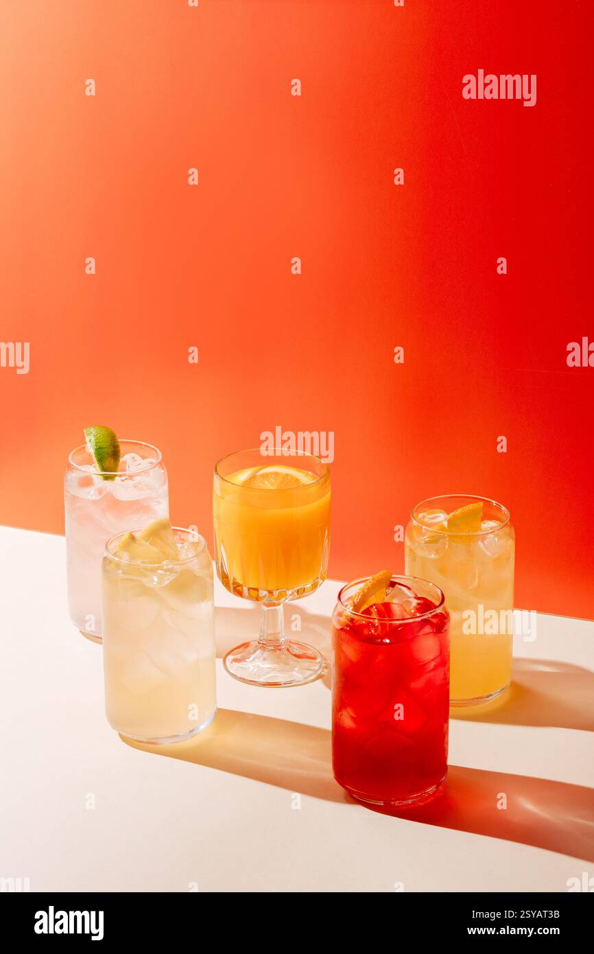 Five assorted lemonades displayed on a surface, set against a bright ...
