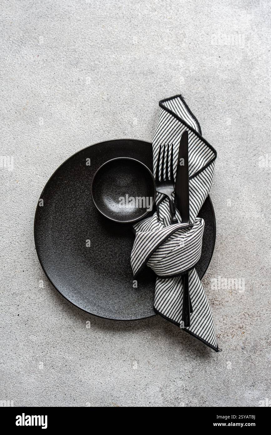 Elegant black and white table setting featuring a black plate, bowl ...