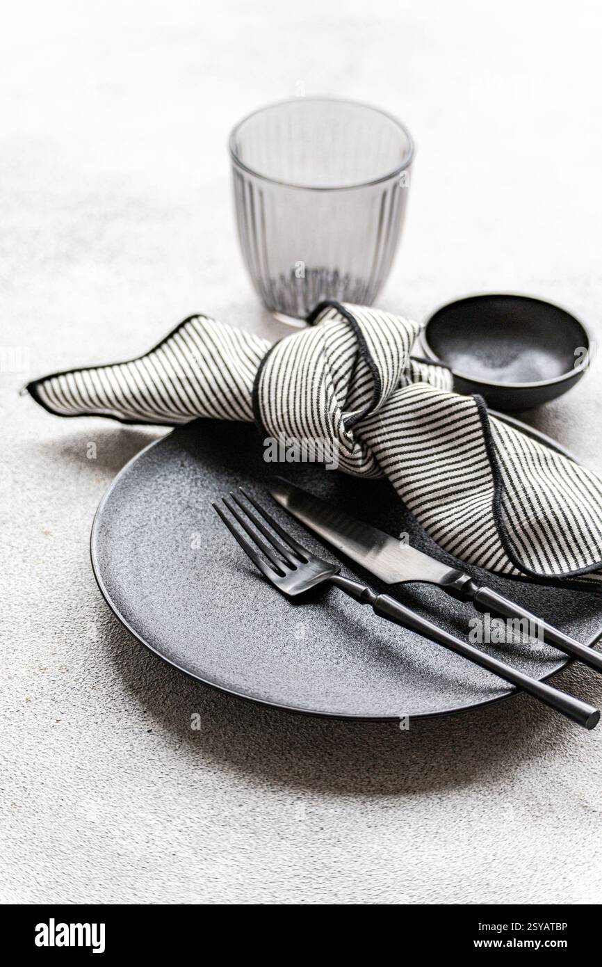 Black and white table setting featuring a textured plate, striped ...