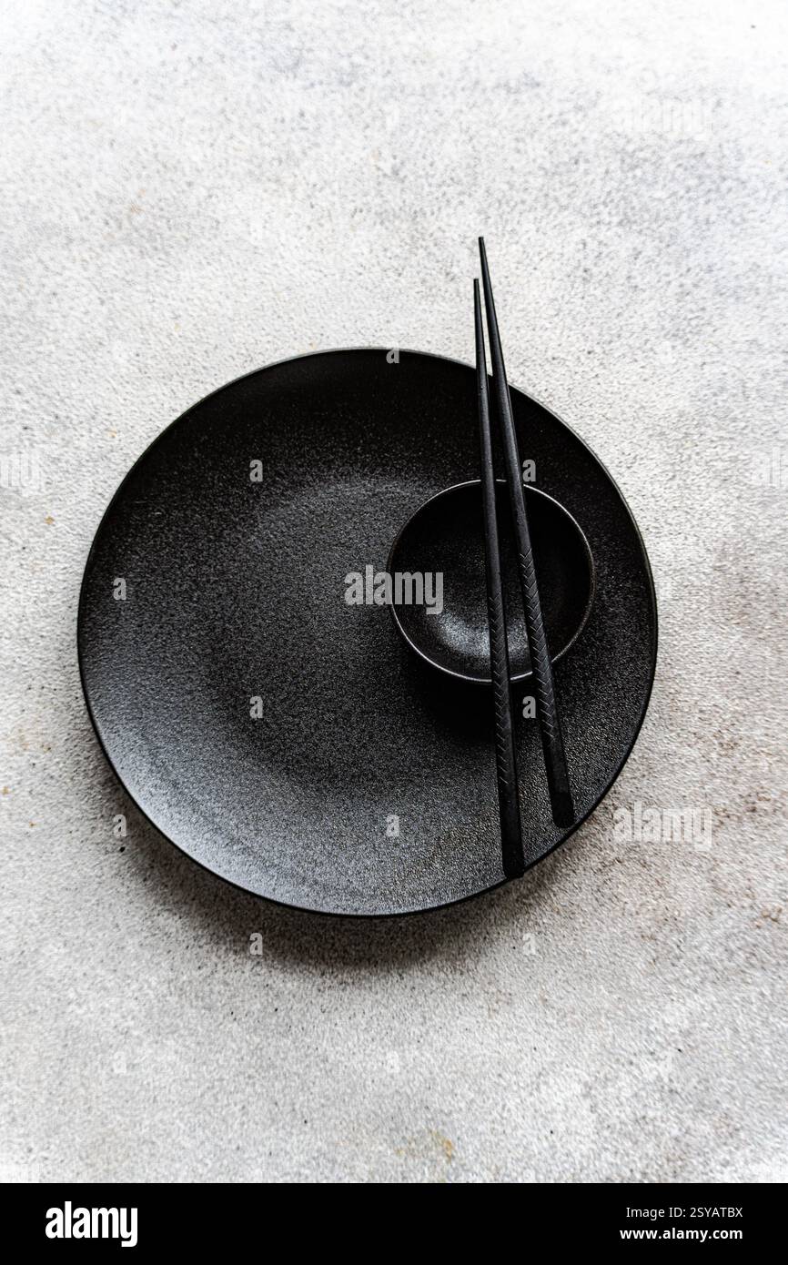 Minimalist black table setting featuring a sleek plate and bowl with ...