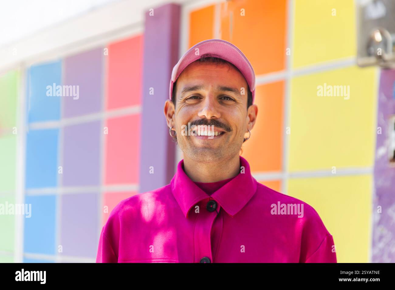 A Spanish man with a mustache models vibrant pink clothing in Quito ...