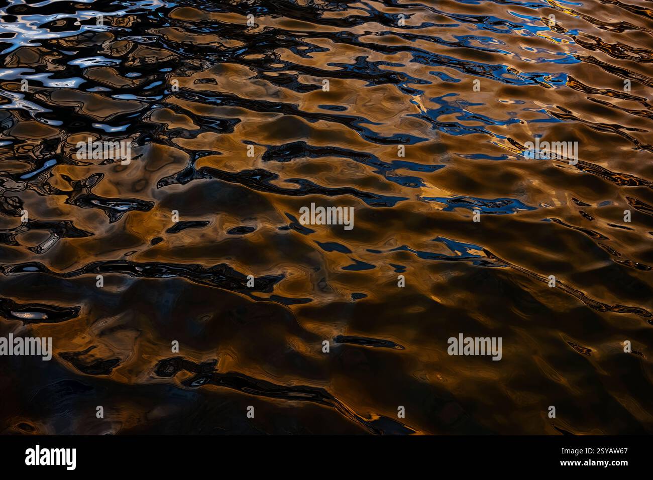 Captivating golden reflections dance on the rippling waters at Playa Blanca Port in Lanzarote ...