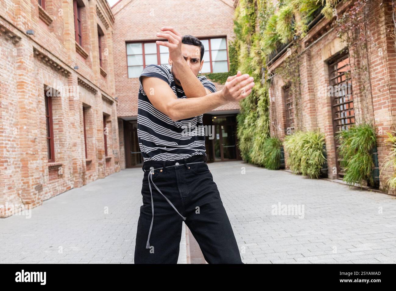 A Cuban man passionately dances outdoors in an urban courtyard ...