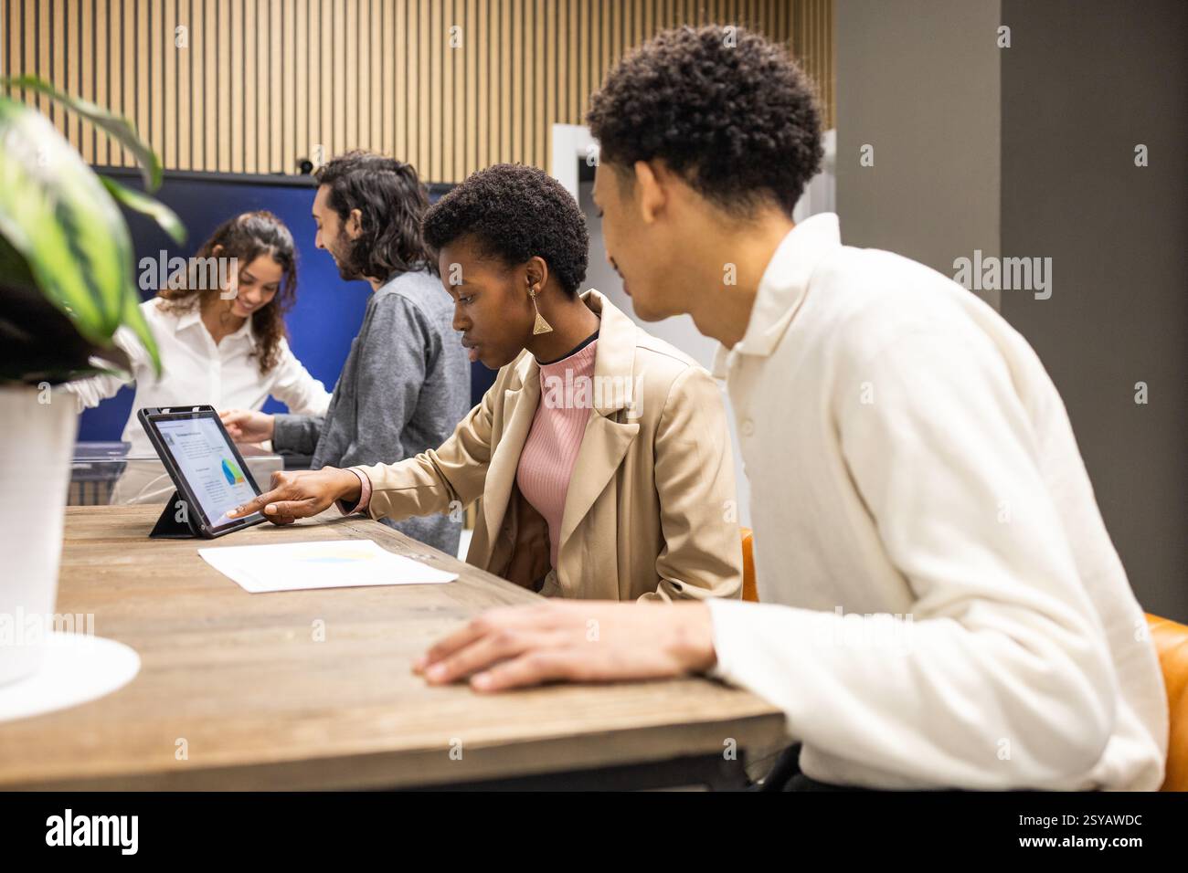 A diverse group of colleagues engage in teamwork in a modern office ...