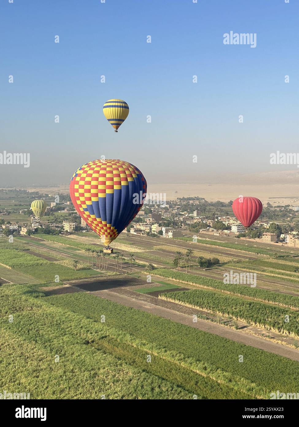 Crops on East bank of Luxor with a red hot air balloon in the morning ...