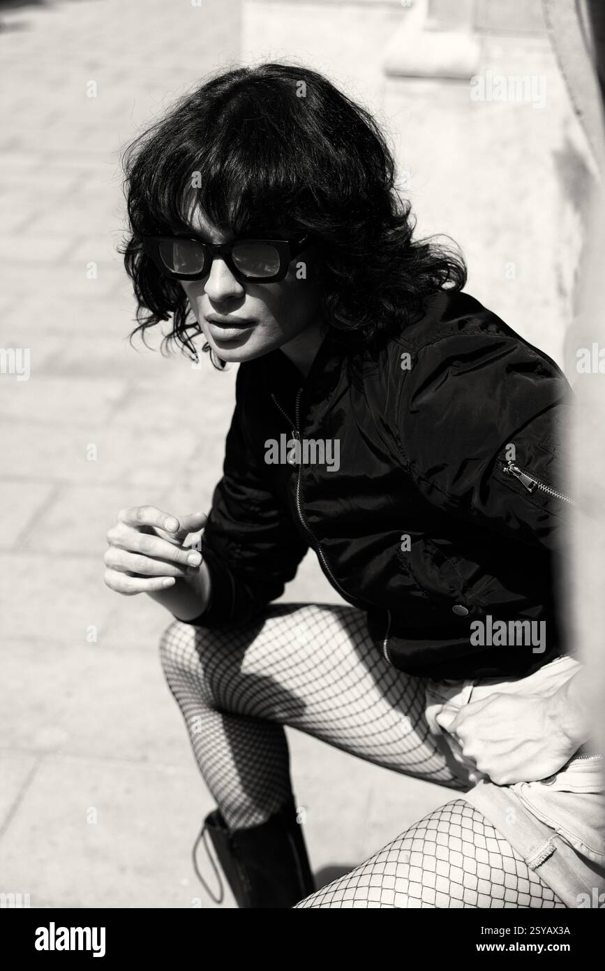 A stylish woman with messy hair and sunglasses exudes confidence in ...