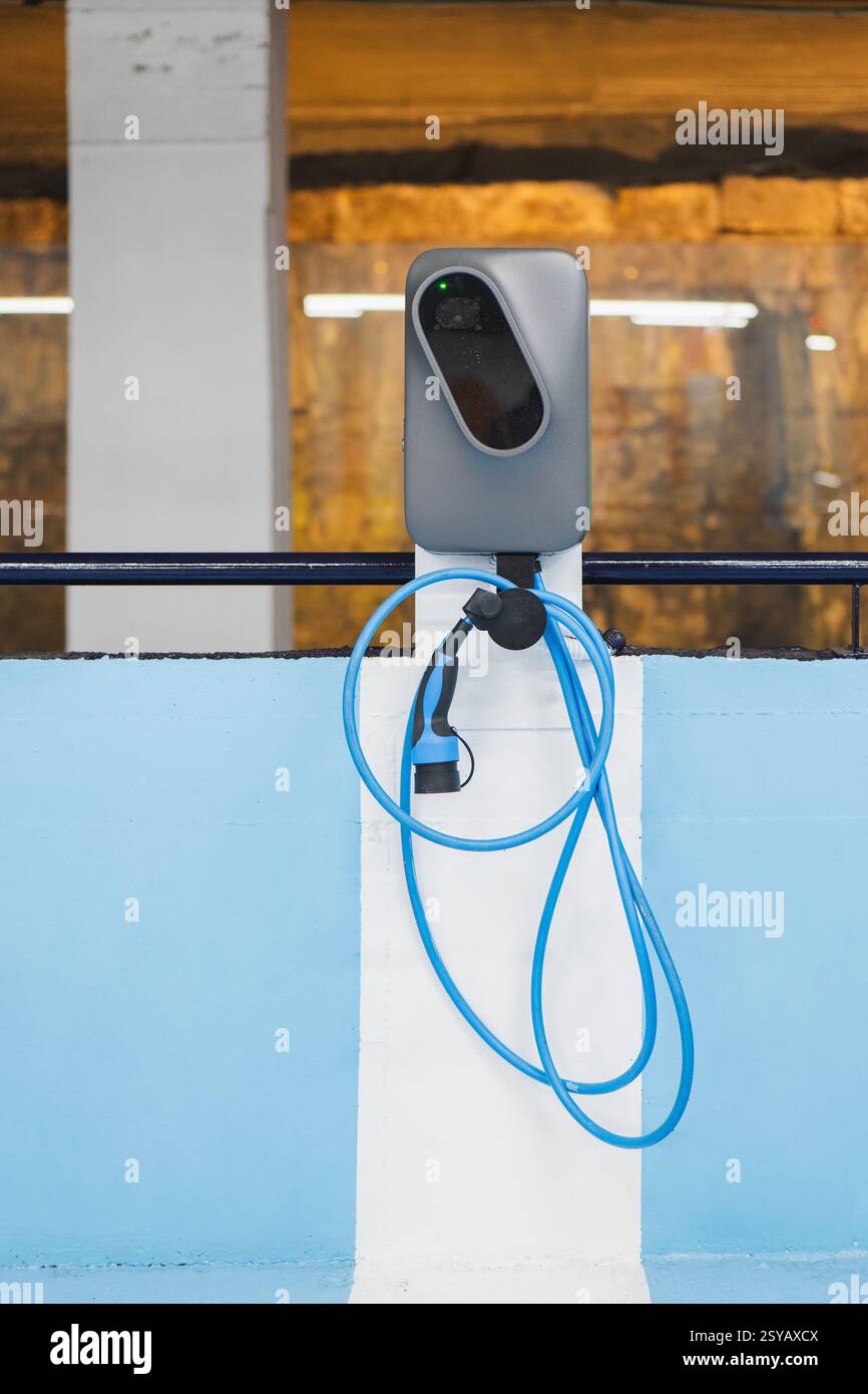 A modern electric vehicle (EV) charging station, equipped with a blue ...