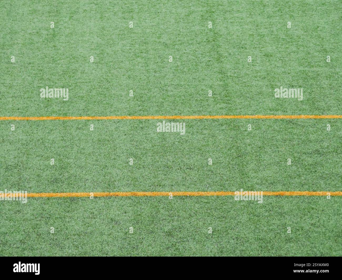 Close up view of green artificial turf featuring parallel yellow lines ...