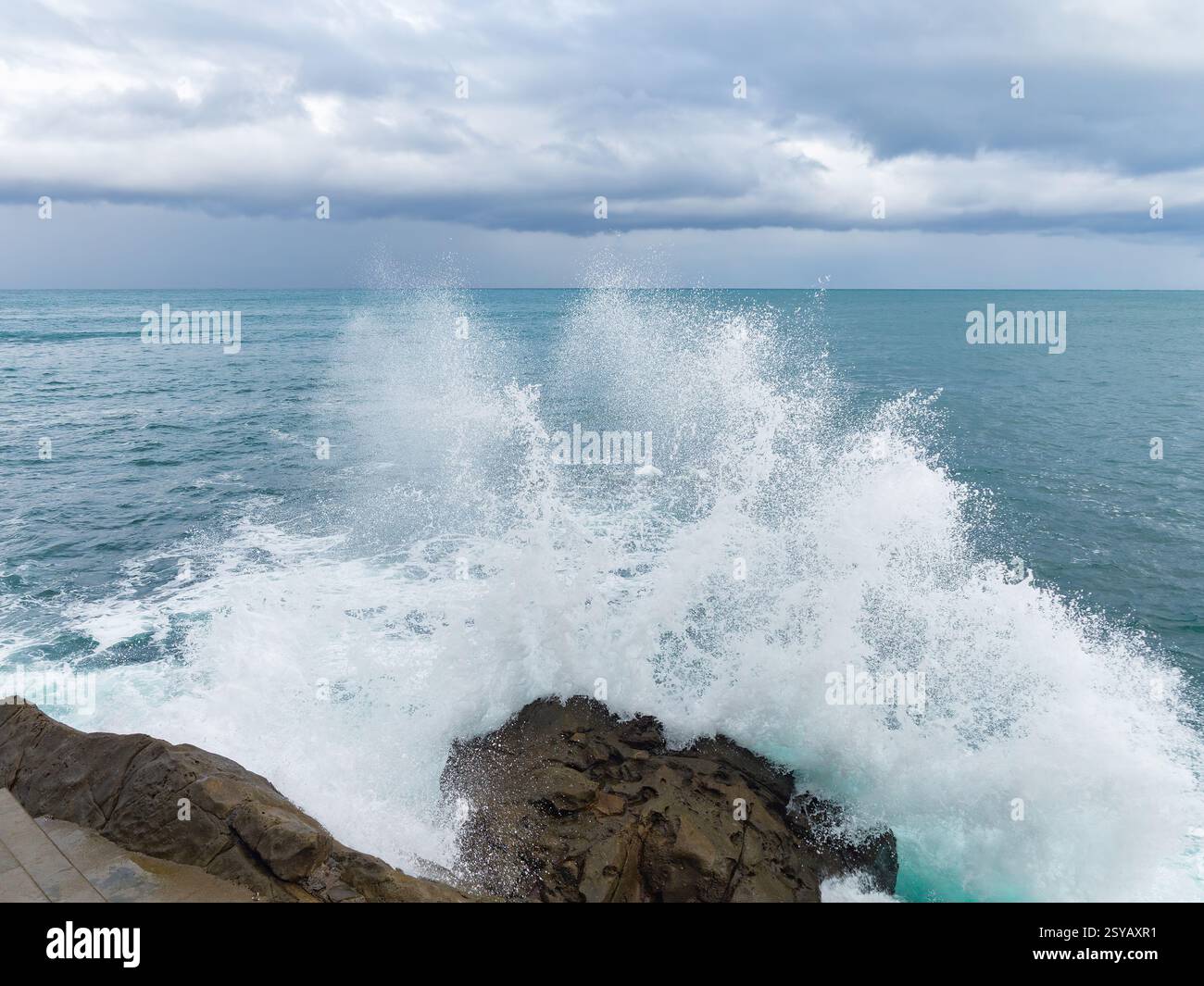A dramatic scene as powerful waves collide with rugged rocks under a ...