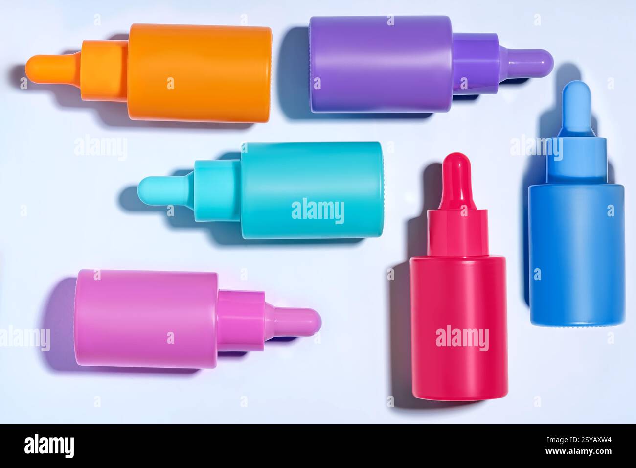 An overhead view of six colorful serum bottles in orange, purple, blue ...