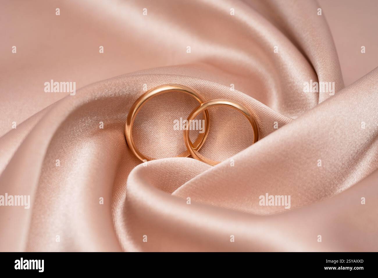 Two golden wedding rings interlocked, symbolizing unity and love, rest ...