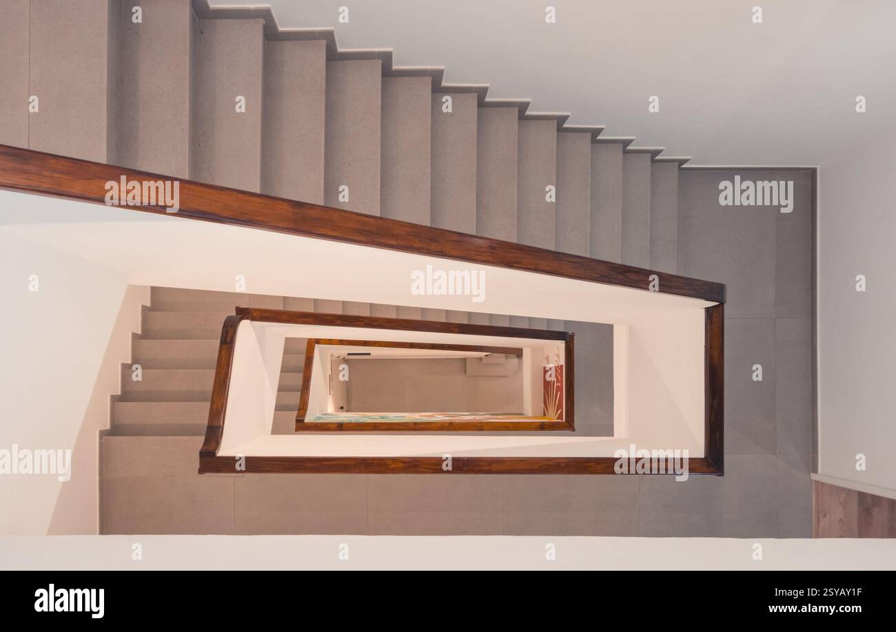 A contemporary staircase featuring warm wooden banisters and successive ...