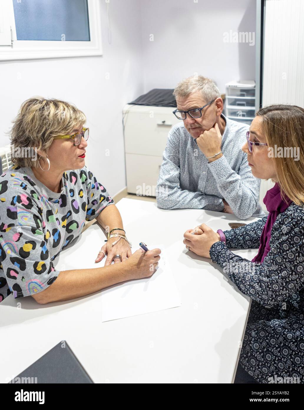 A woman and a couple with intellectual disabilities sit in an ...