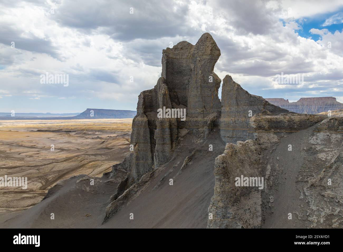 A towering rock formation emerges from the expansive desert landscape ...