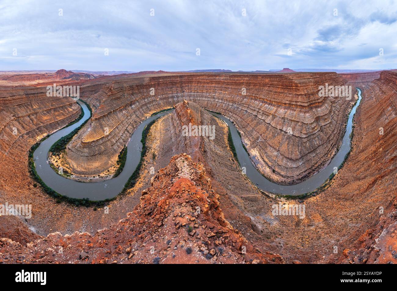 A breathtaking view of a winding river carving through a deep, red rock ...