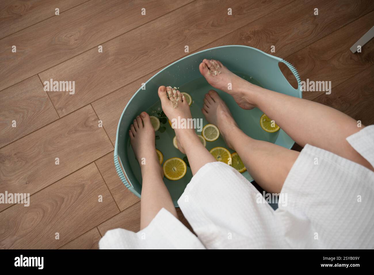 A mother and daughter indulge in a relaxing home foot spa. They are ...
