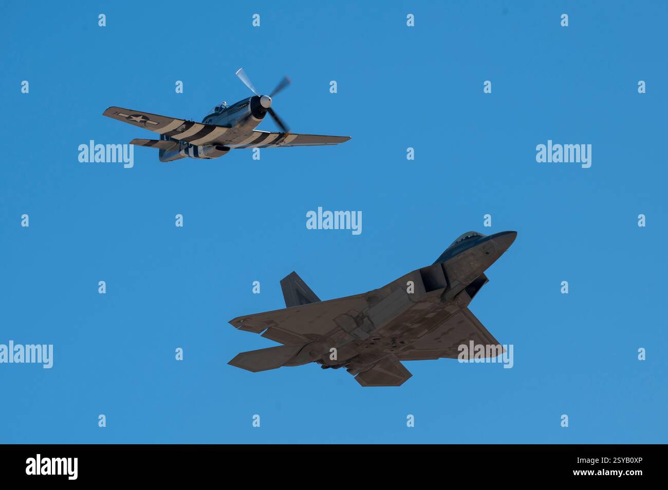 A U.S. Air Force F-22 Raptor aircraft flies in formation with a P-51 ...