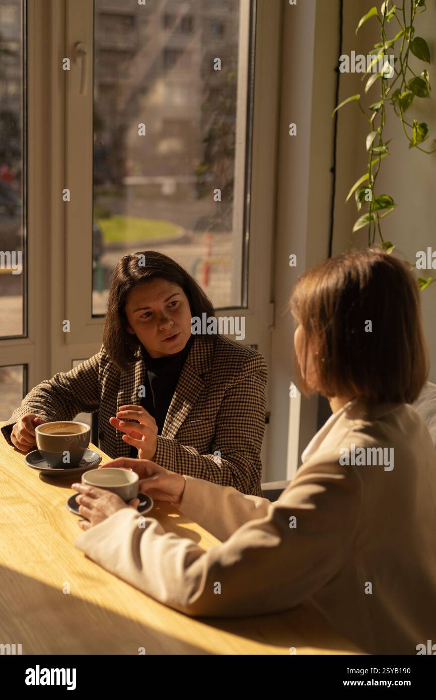 two women talk over coffee in a cafe Stock Photo - Alamy