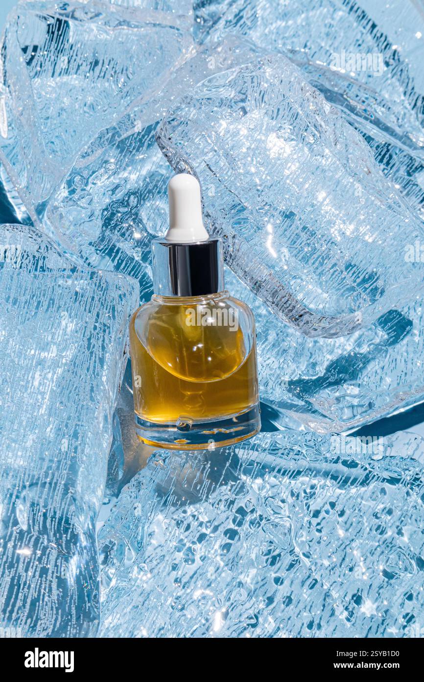 An elegant glass serum bottle with a dropper filled with golden liquid ...