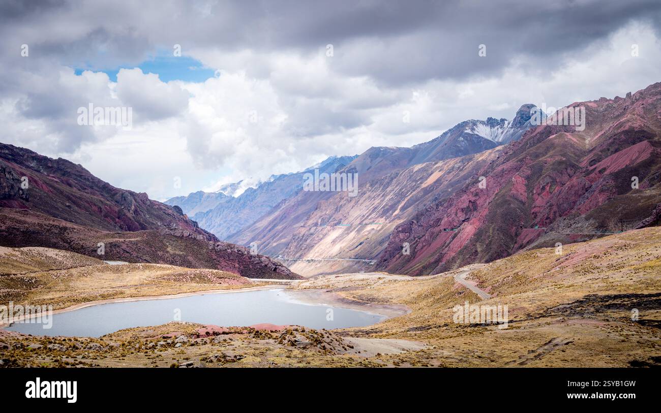 Majestic red mountains of the Peruvian Andes surround a tranquil lake ...