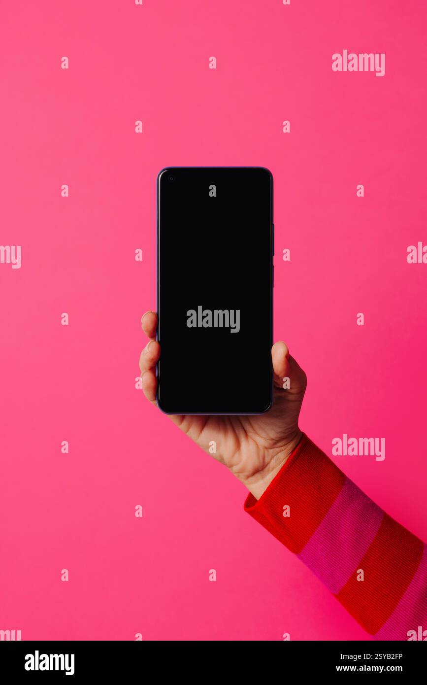 Crop anonymous person in casual clothes showing modern smartphone with ...