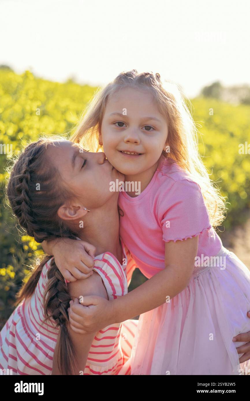 A sweet moment between two sisters as one gives the other a kiss on the cheek Their embrace ...