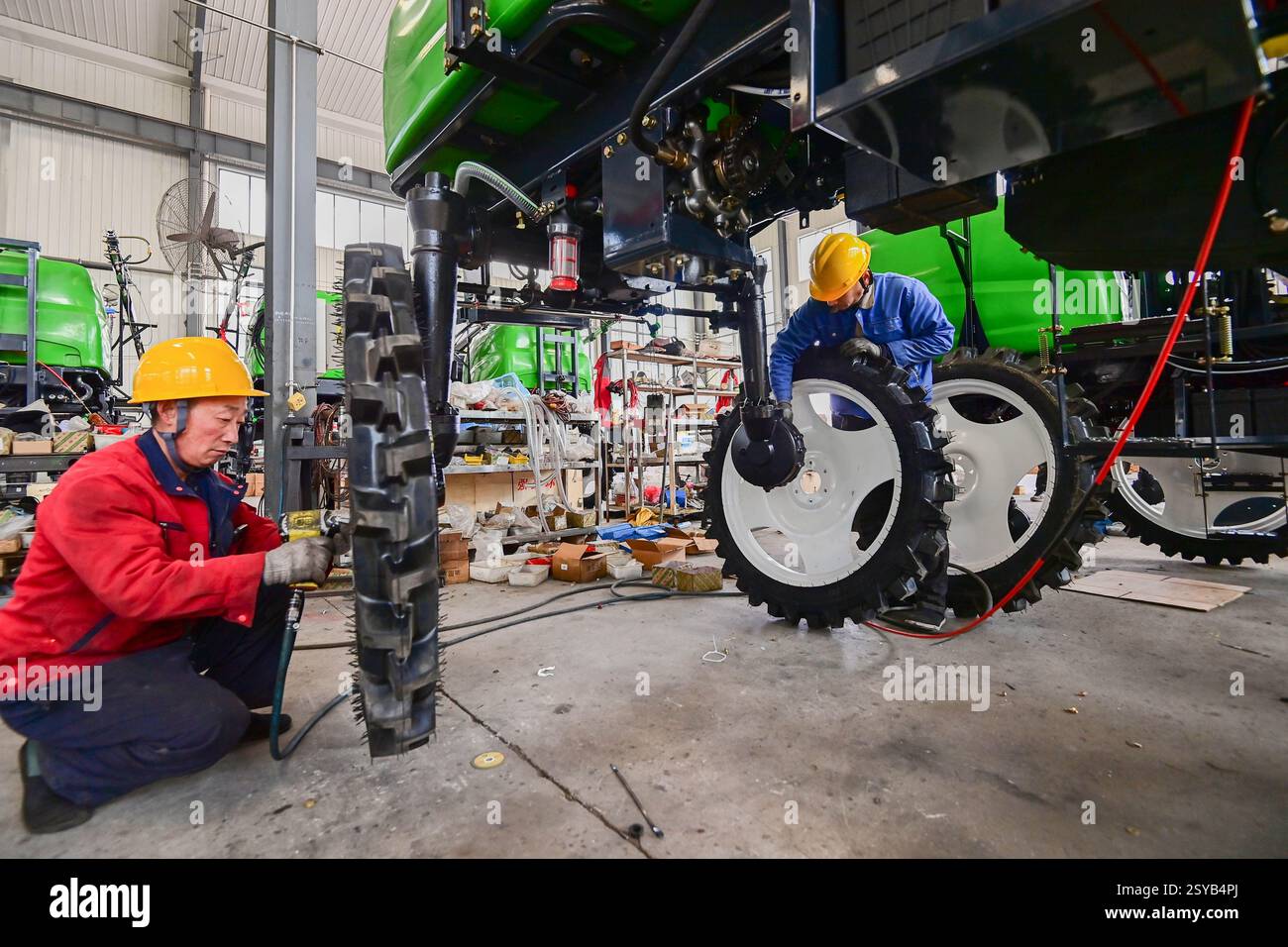 A worker assembles a plant protection machine at a workshop in Qingzhou ...