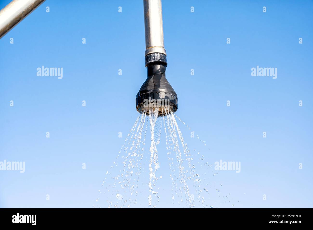 Close-up of a pool shower with uneven water flow, obstructed by lime ...