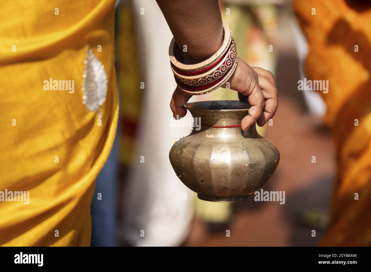 A devotee hold a lotah of milk to offer on Shiva linga on the occasion ...