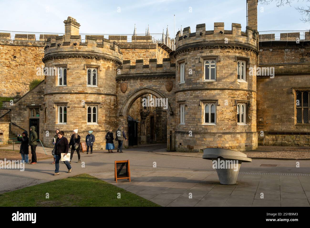 People inside entrance gateway to Lincoln castle, city of Lincoln ...