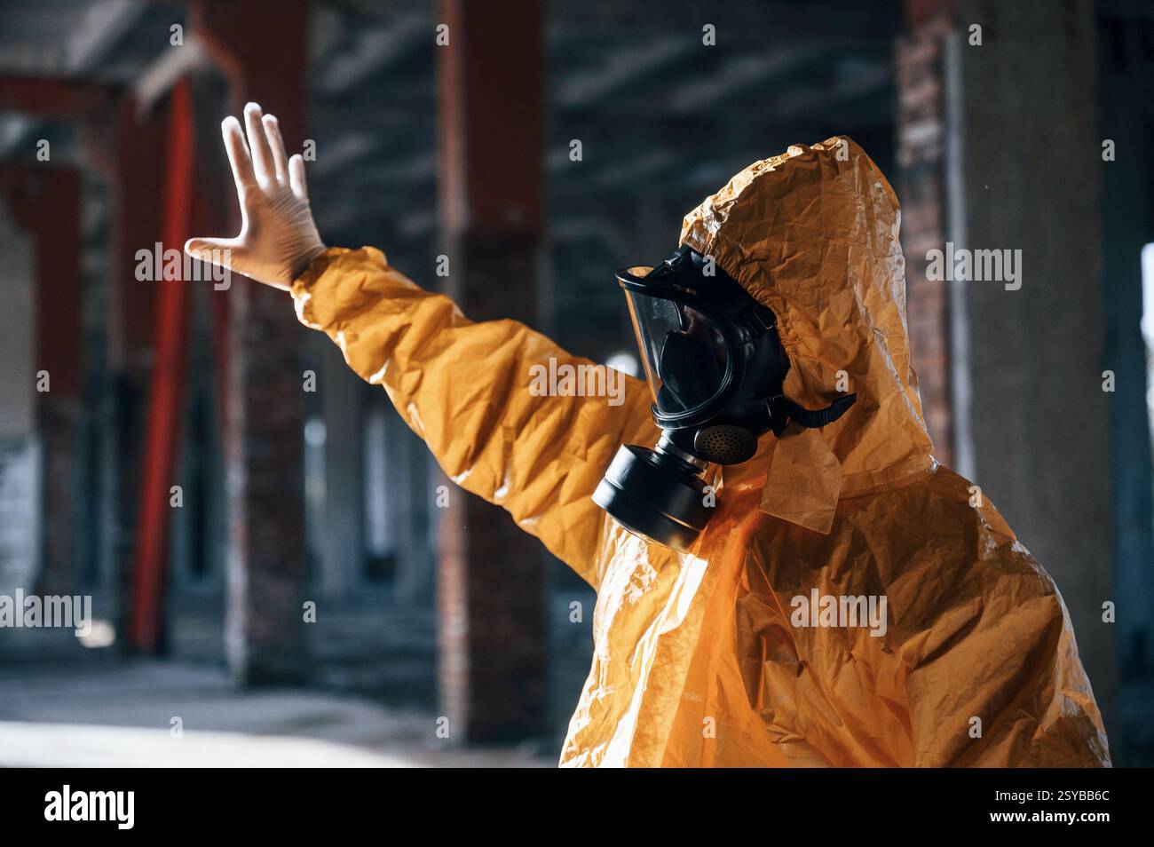 Nuclear explosion. Man dressed in chemical protection suit in the ruins ...