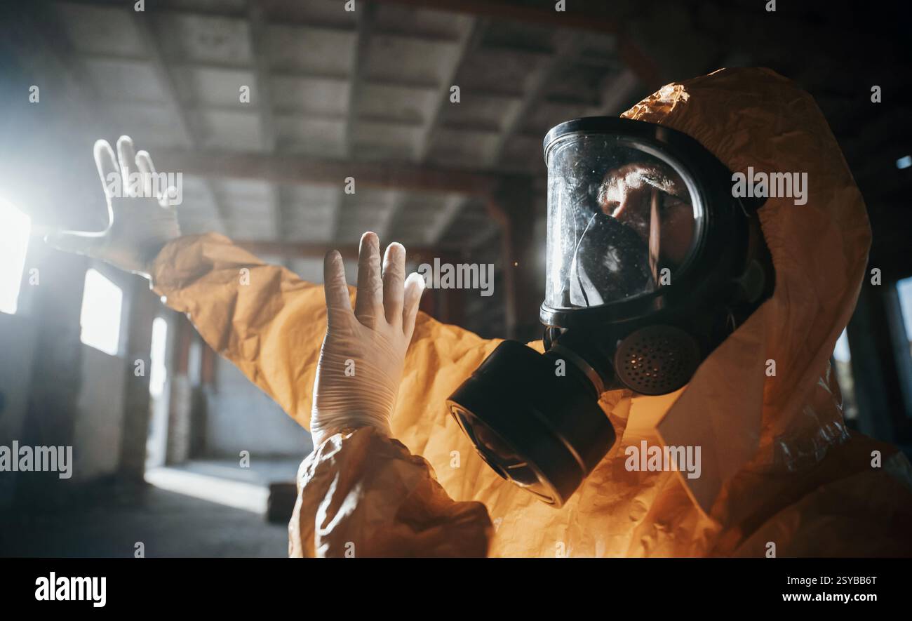 Light from nuclear explosion. Man dressed in chemical protection suit ...