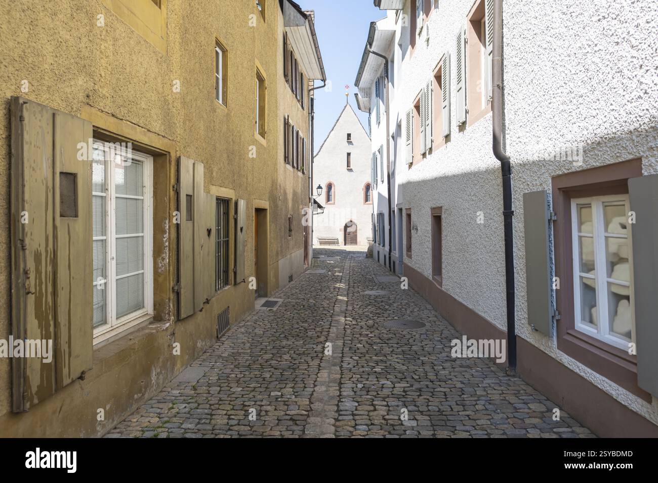 Narrow alley between historic buildings with shutters and cobblestones ...