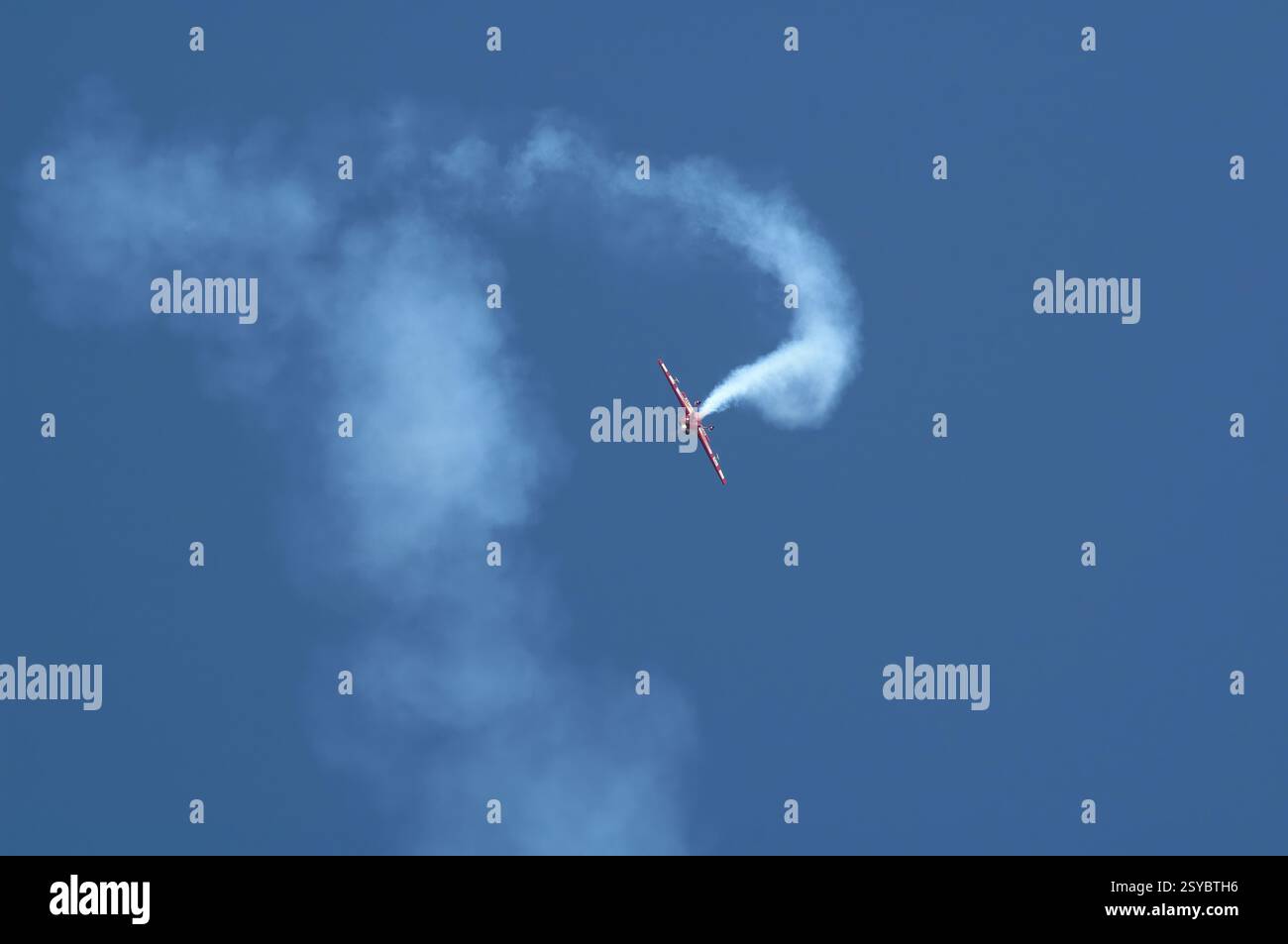 Piper plane leaves a smoke trail in the sky while performing ...