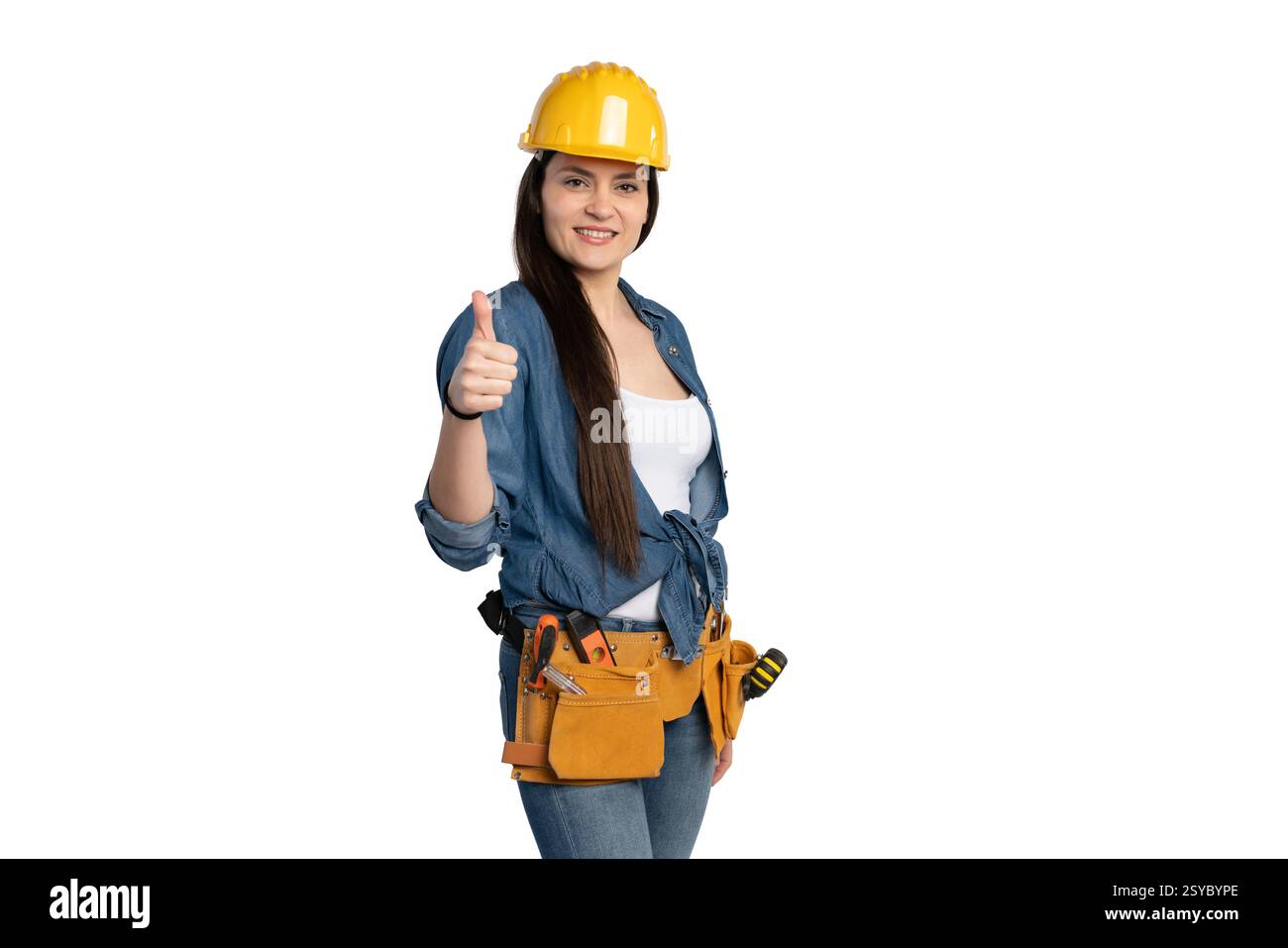 A young female construction worker in a denim shirt, white tank top, and tool belt gives a ...