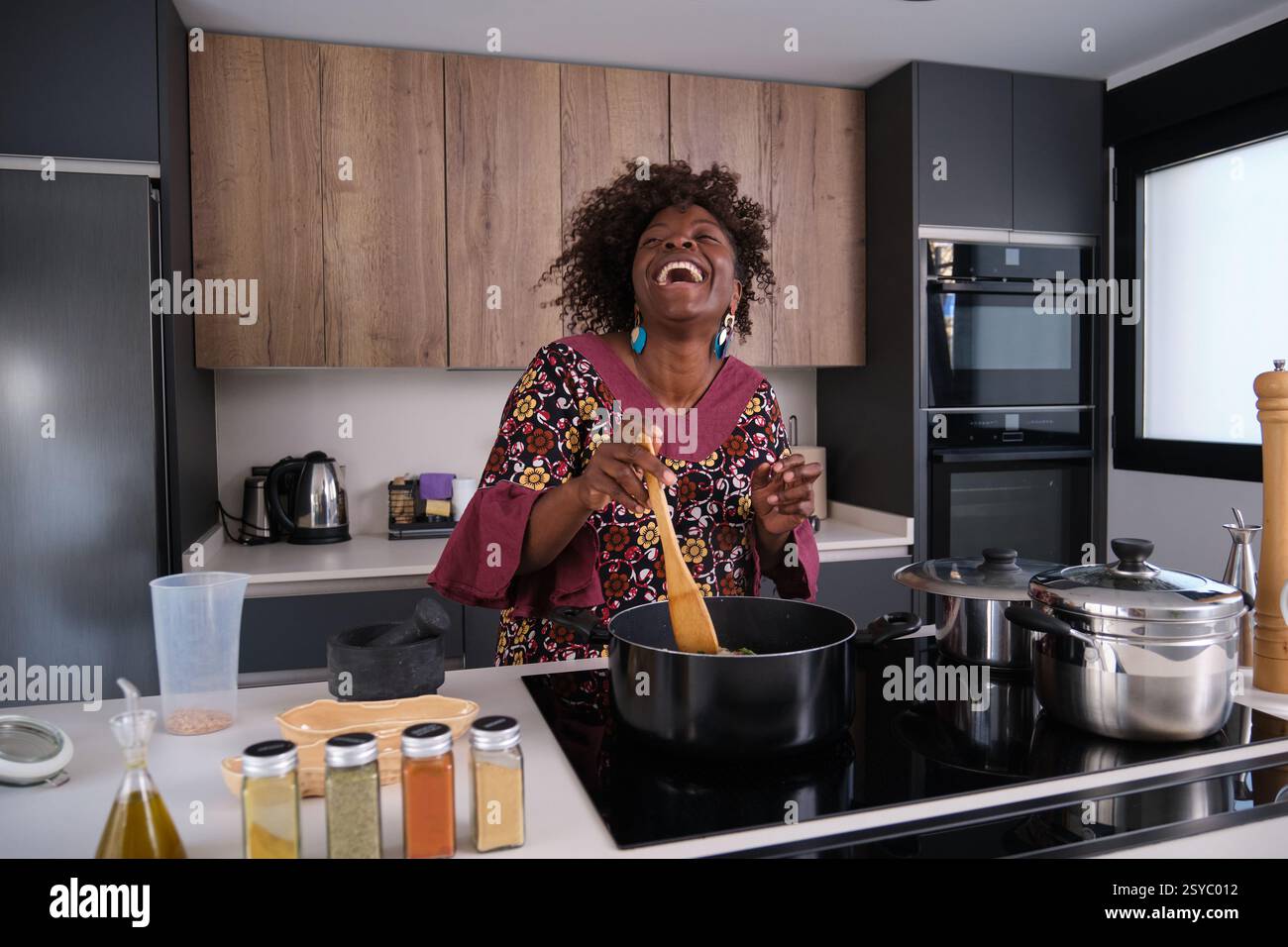 Happy African Woman Cooking Okra Soup with Spinach in Modern Kitchen ...